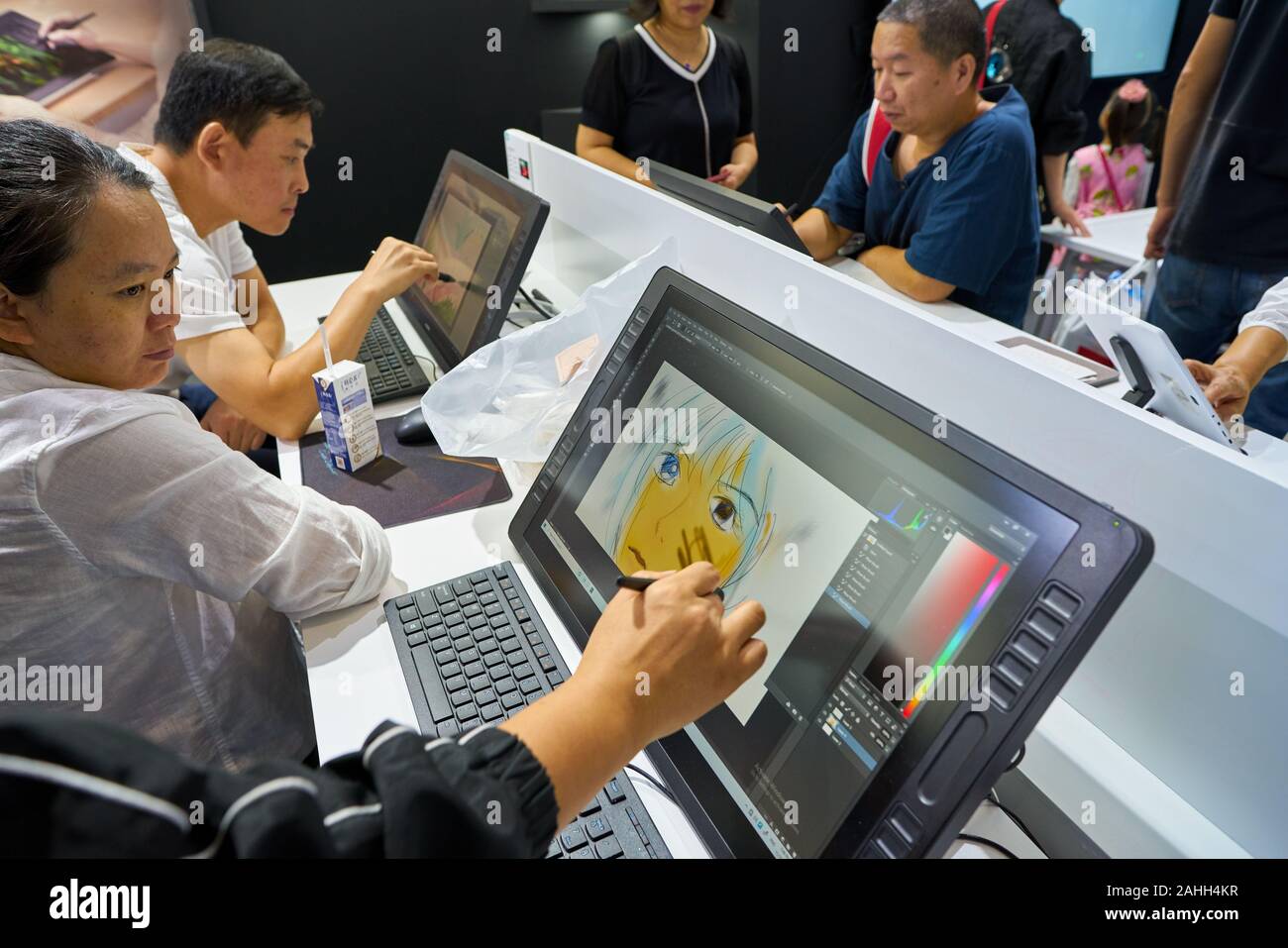 SHENZHEN, CHINA - CIRCA NOVEMBER, 2019: people try Huion device at ...