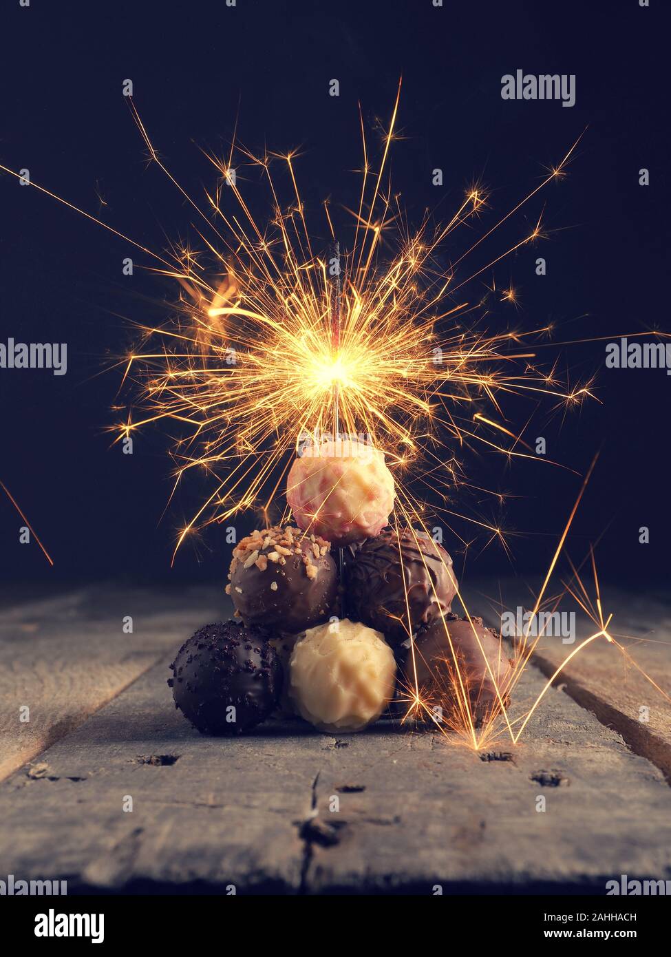 Stacked chocolated balls on a rustic table with a sparkler Stock Photo ...