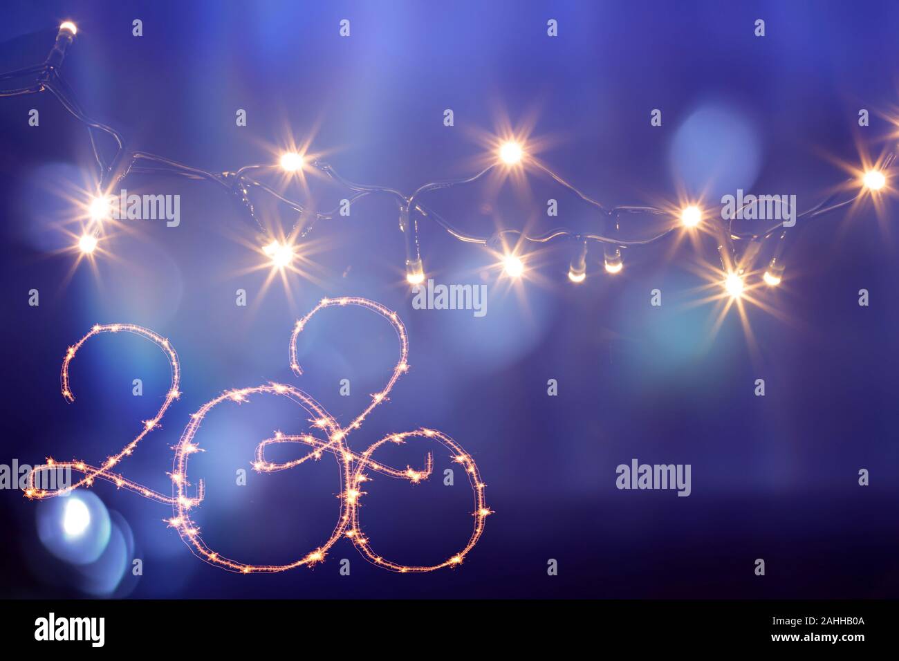 New Year 2020 celebration. Magic holiday background with lights. Number ...