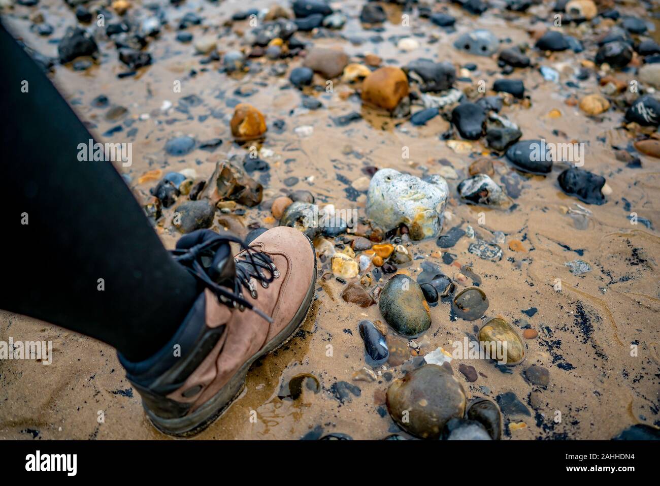 Selective focus of a lady wearing walking boots standing in a shallow ...