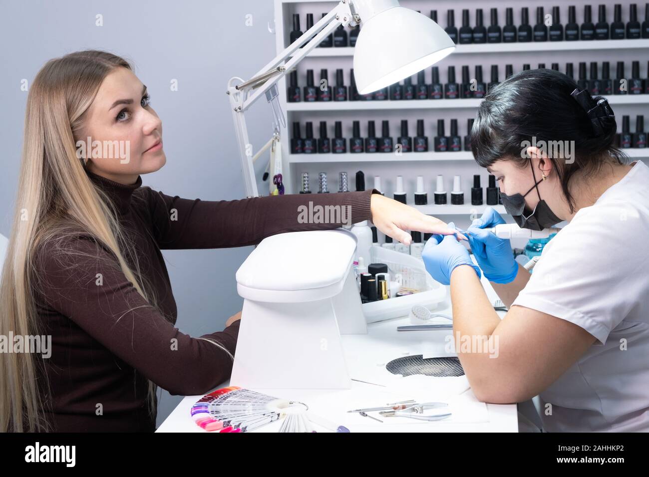 hardware manicure in a beauty salon. Manicurist is applying electric ...