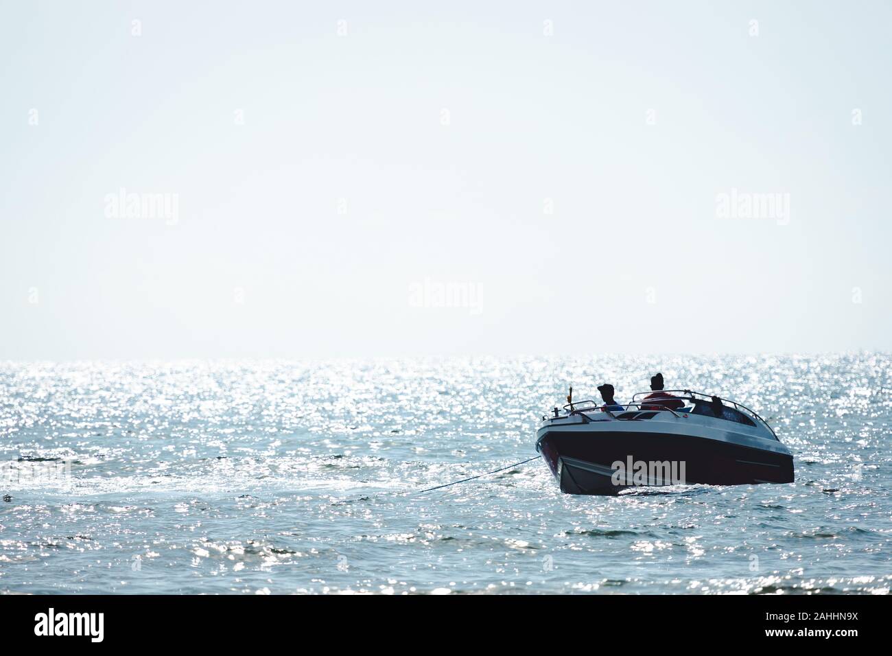 Silhouette mini speed boat for hook parachute playing on the sea water ...