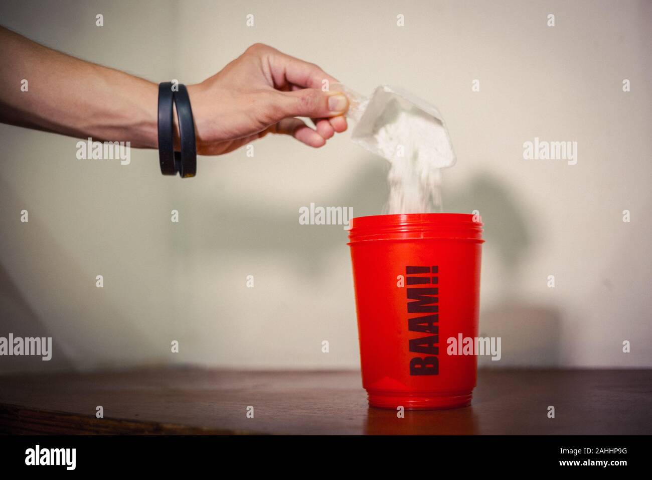hand pouring whey protein into bottle for shake Stock Photo - Alamy