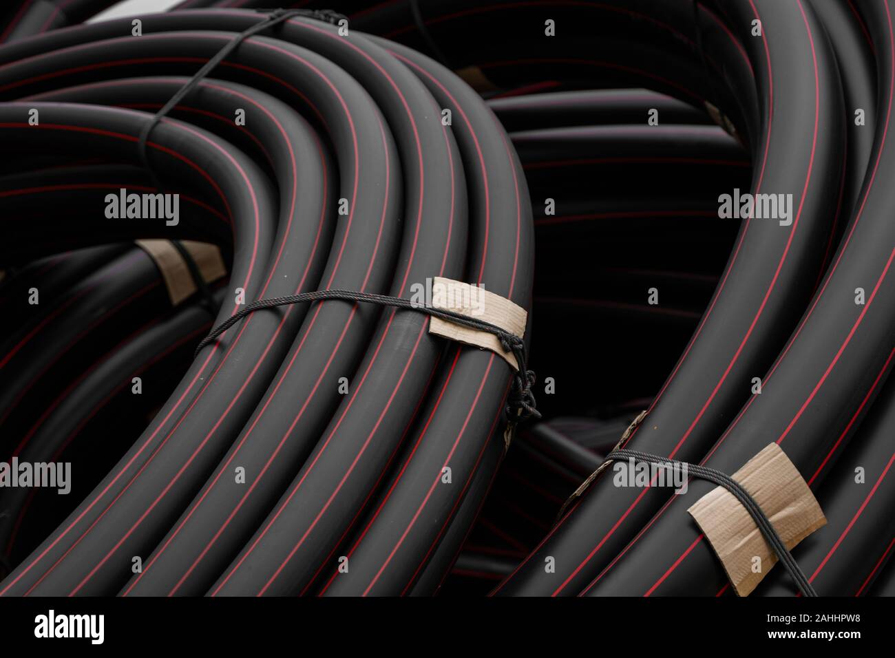 Black rubber or plastic pipes with a red lines as a construction ...