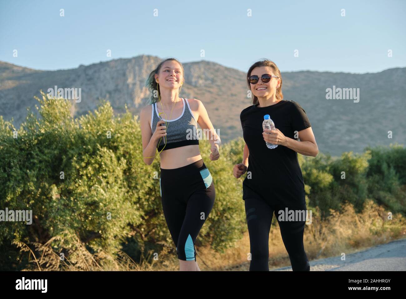 Active sports family parent and child teenager running outdoor. Mother ...