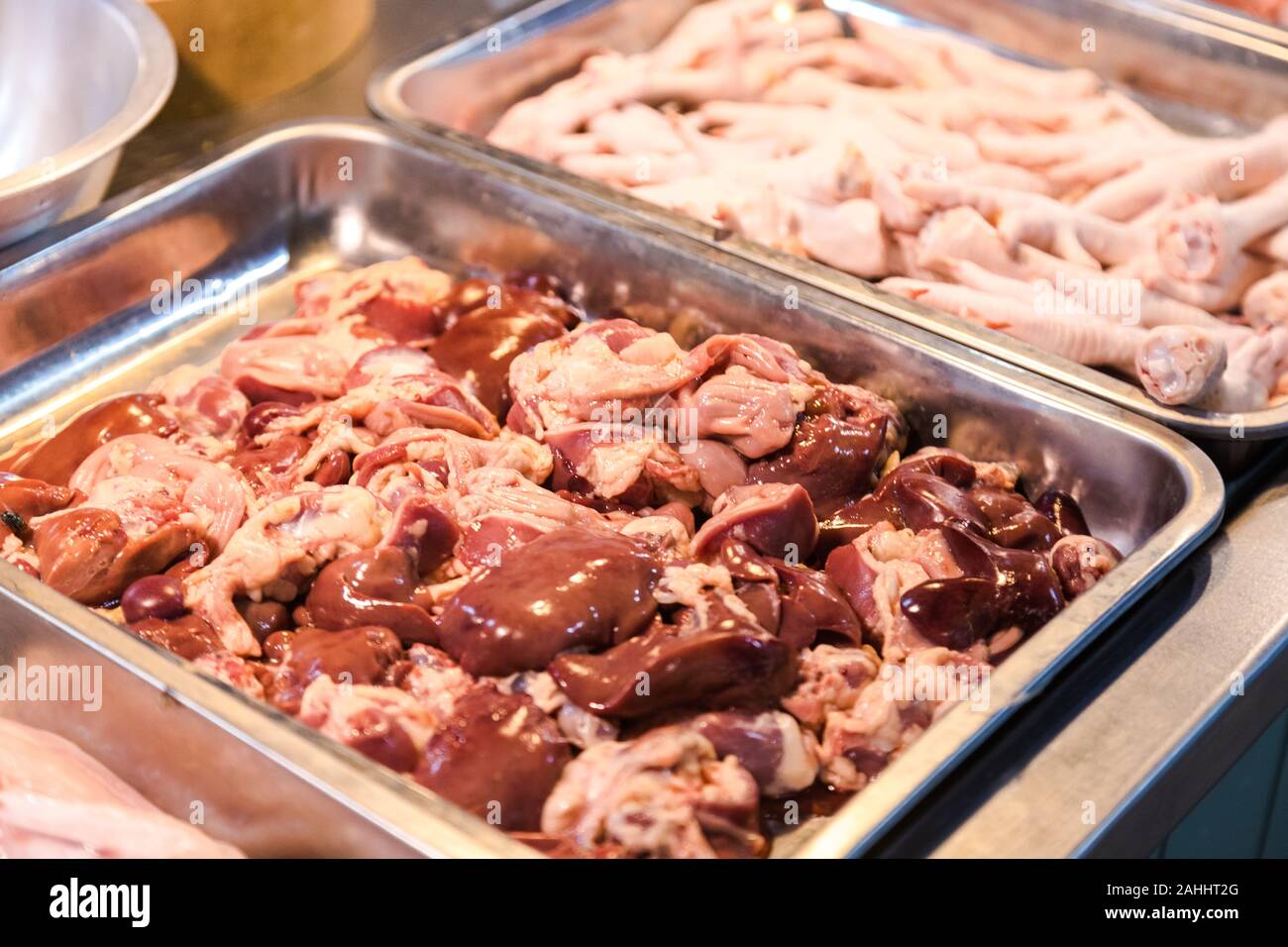 Chicken organ in tray for sell at market with chicken feet beside Stock ...