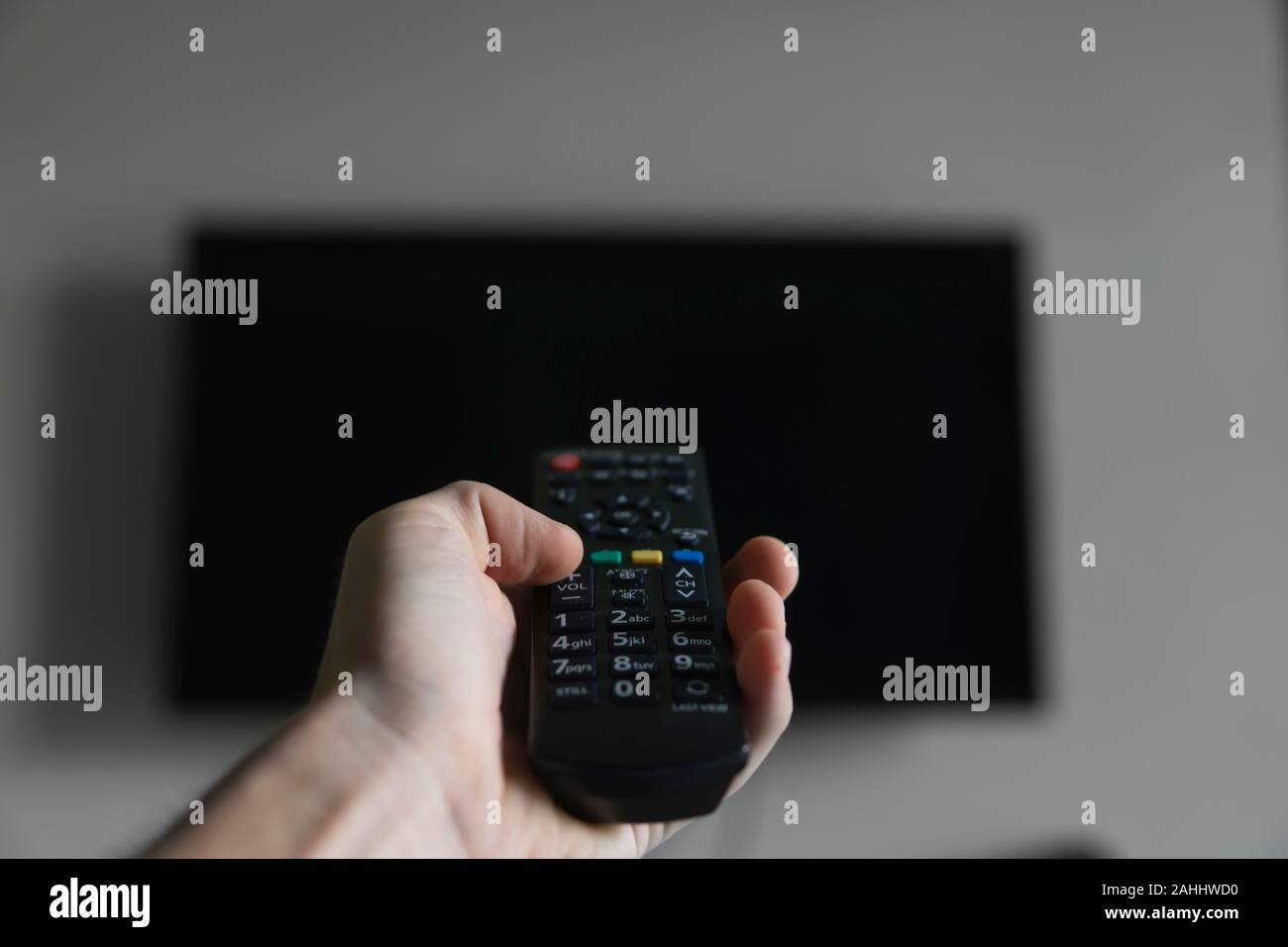 The man with the remote control in hand want switch on the TV and ...