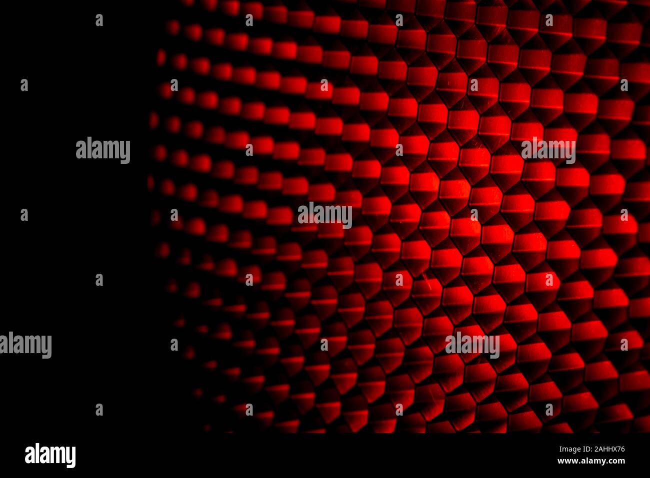 Closeup honeycomb grid texture with red light. Red and dark metal ...