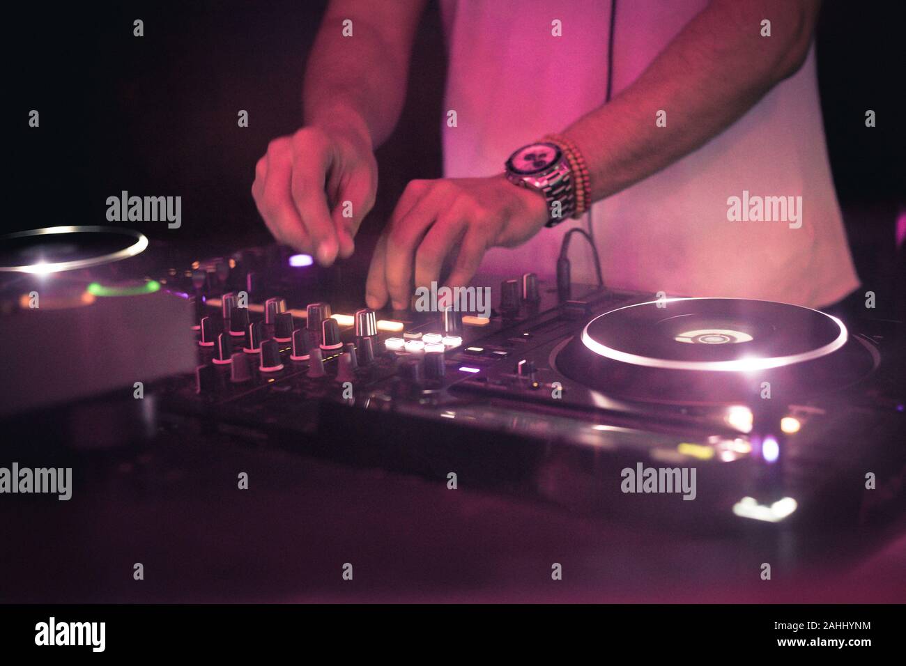 DJ is mixing some music with controller in nightclub Stock Photo - Alamy