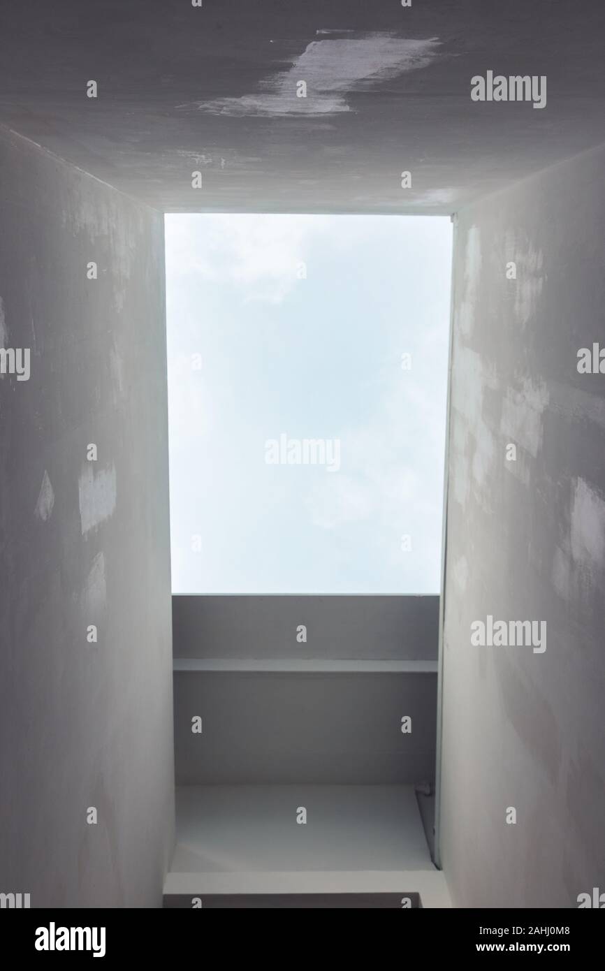 Empty channel of building lead up to show soft blue sky. Square shape ...