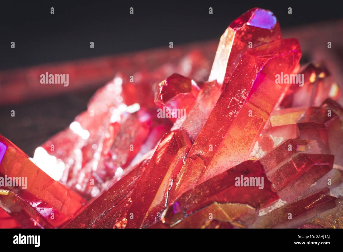 Red Aura Quartz with light shine on, to show how glitter it is on black ...