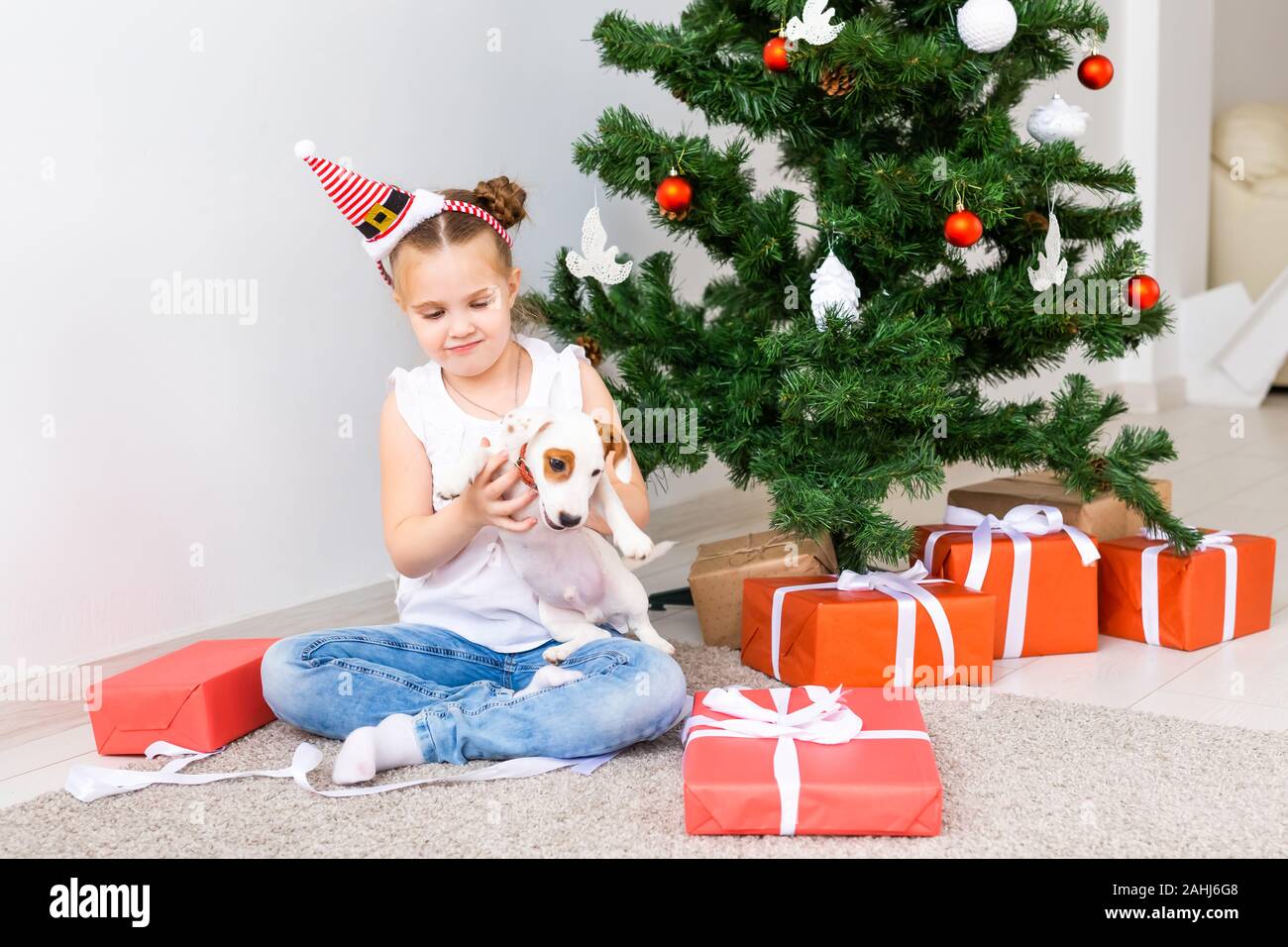 Kid opening Xmas presents. Child under Christmas tree with gift boxes ...