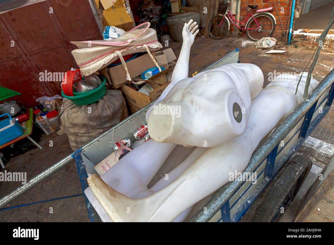 Discarded plastic store mannequins rest in a cart near their home ...