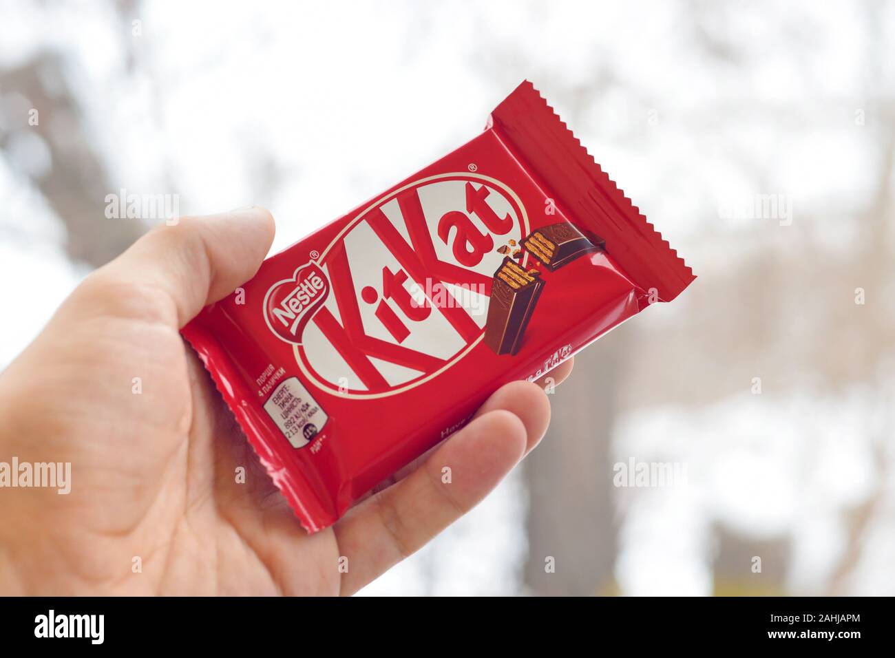 NY, USA - DECEMBER 4, 2019: Kit Kat chocolate bar in male hand on snowy ...