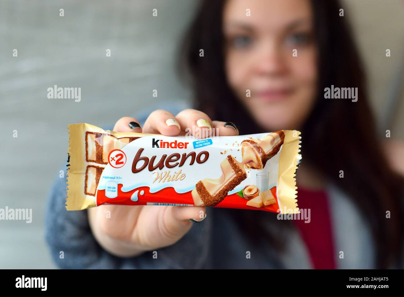 NY, USA - DECEMBER 15, 2019: Young woman shows Kinder Bueno white ...