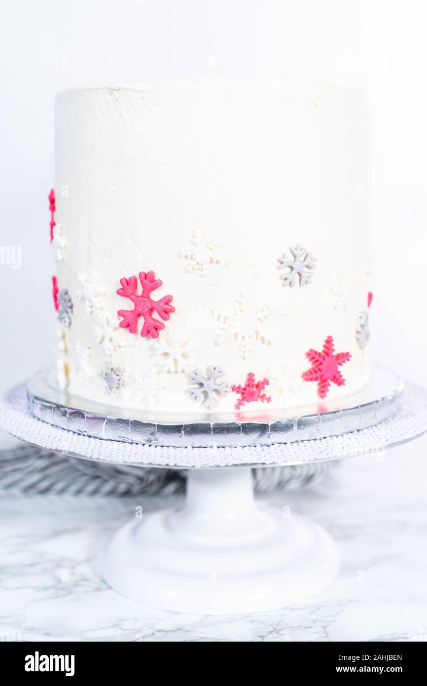 Frosting a tall round cake with white Italian buttercream icing and ...