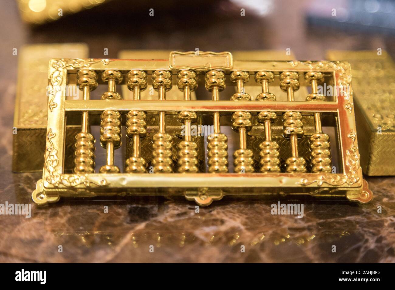 golden abacus put in front of one kilo gold, they're on luxury marble ...