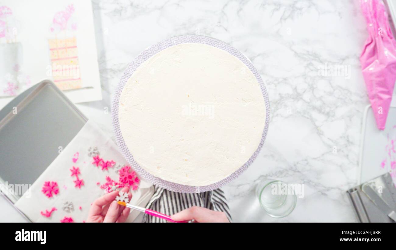 Flat lay. Step by step. Decorating round funfetti cake with pink and ...
