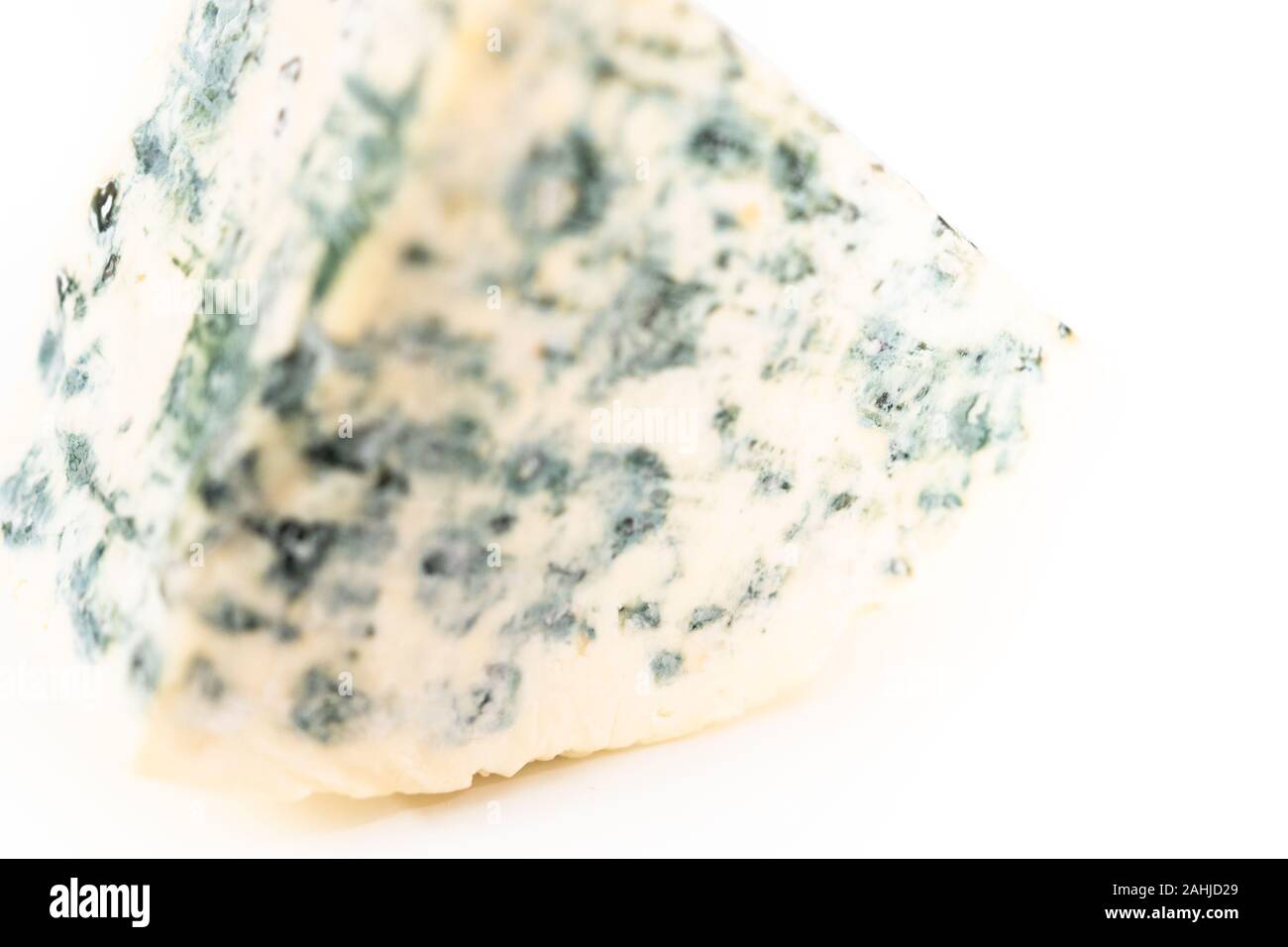 Large slice of blue cheese on a white background Stock Photo - Alamy