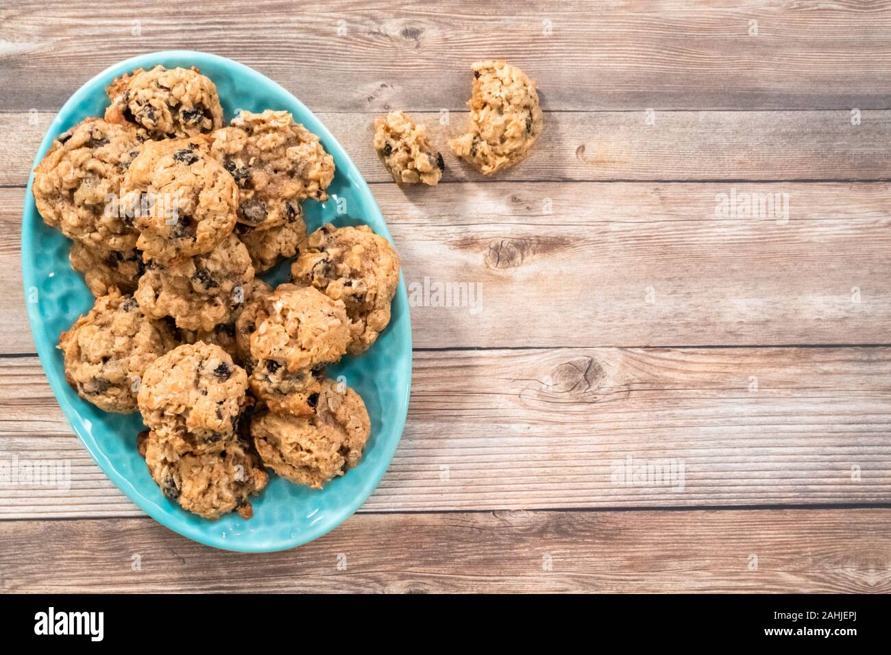 Flat lay. Freshly baked chewy oatmeal raisin cookies on a blue plate ...