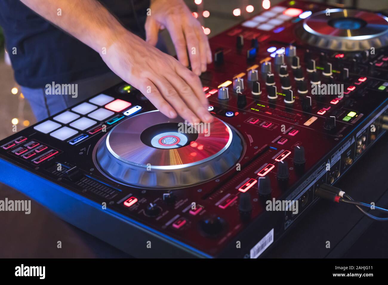 DJ is mixing some music with controller at outdoor night party, by ...