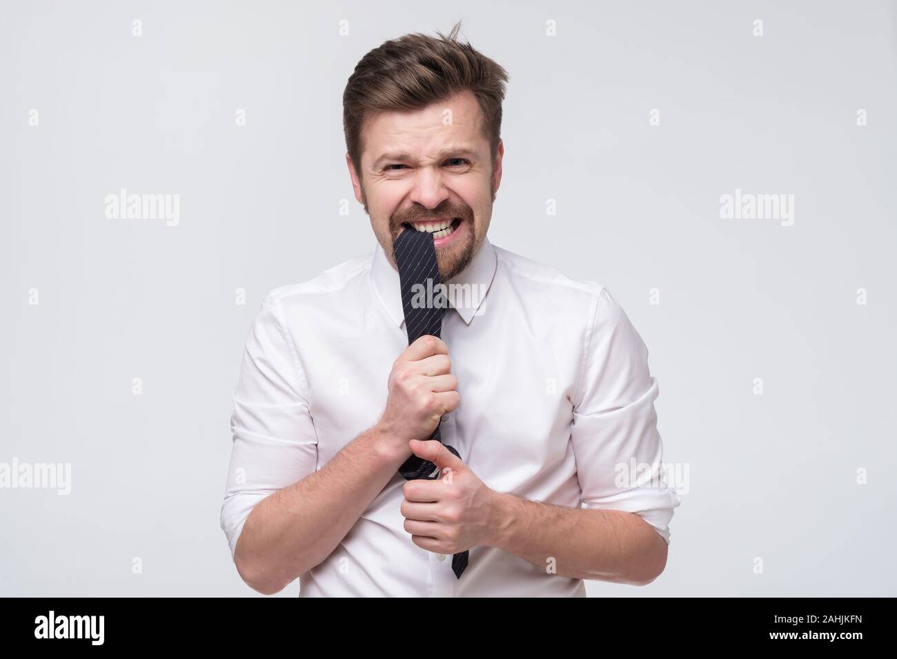 adult man with a mustache chewing his necktie feeling stressed and ...