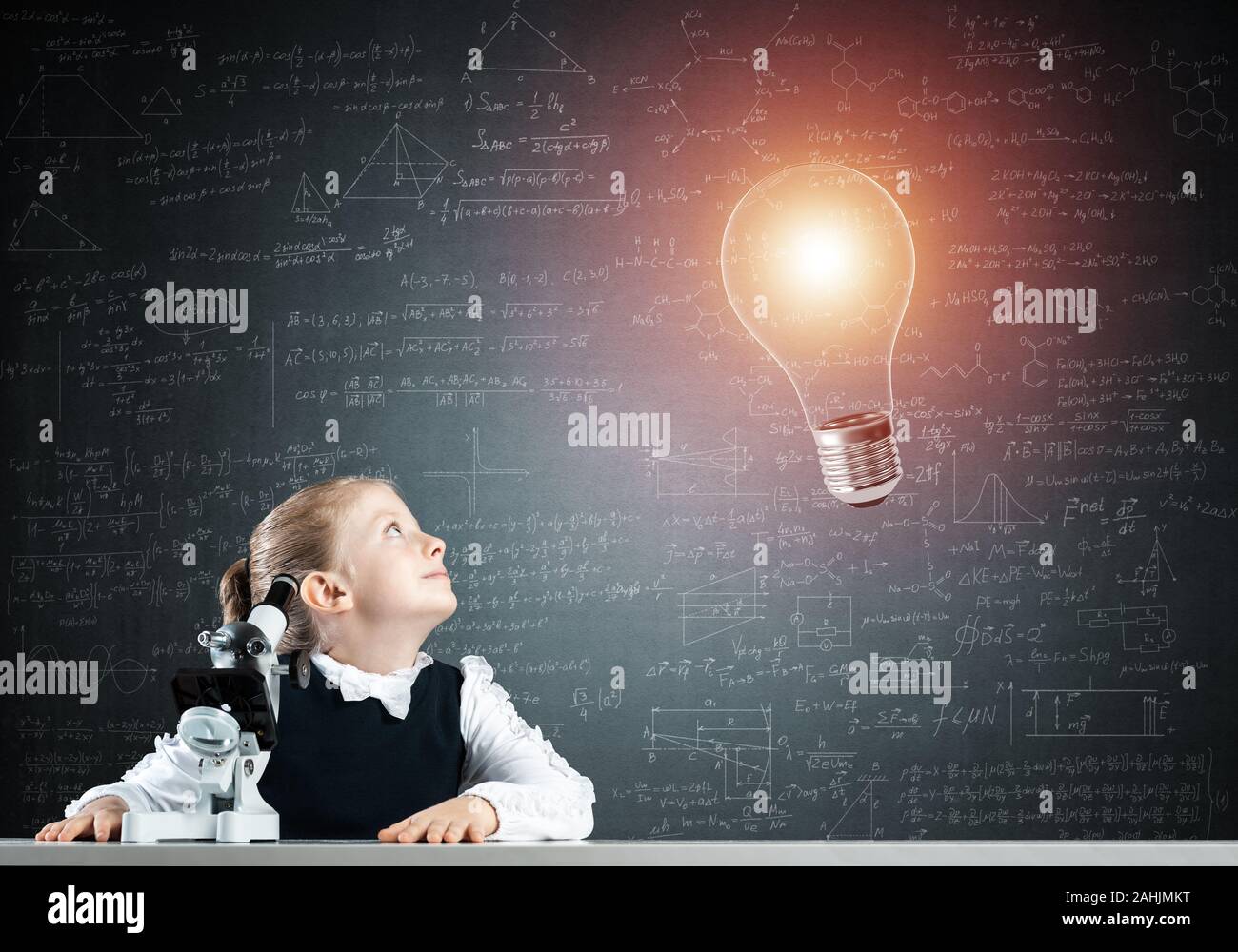 Little girl scientist with microscope on chalkboard background with ...