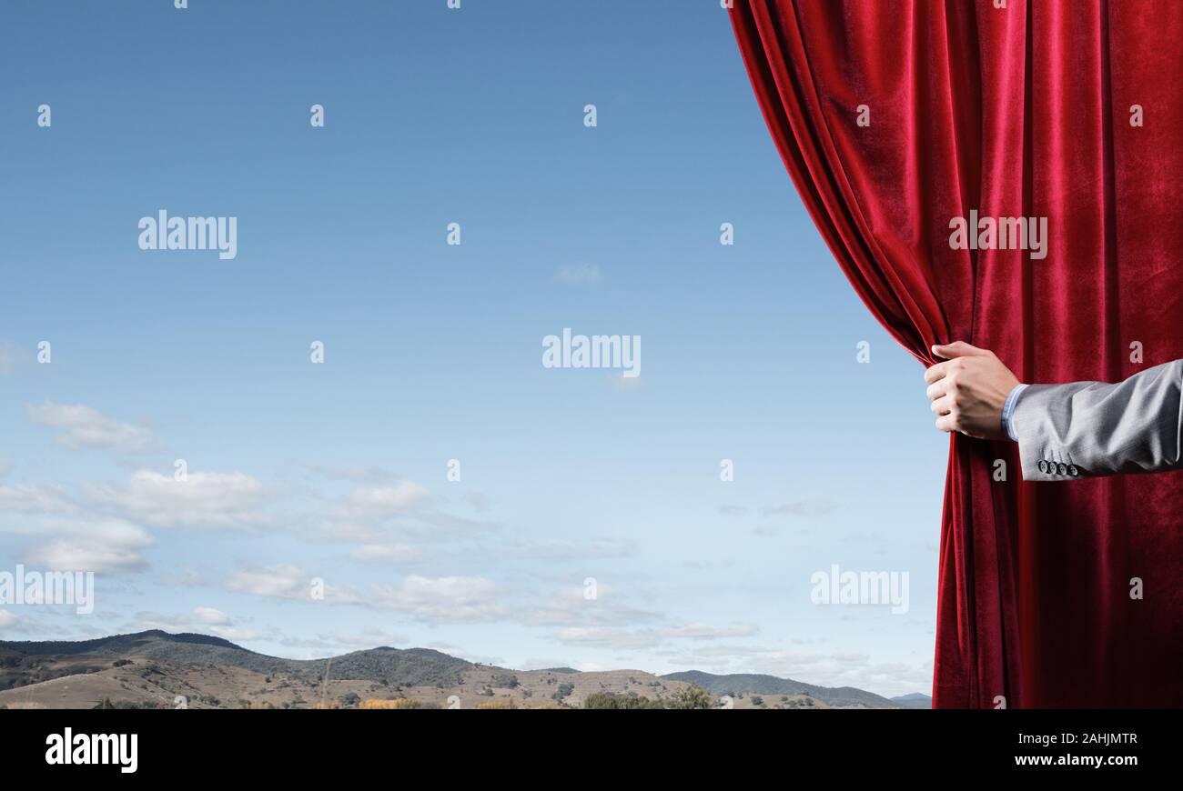 Human hand opens red curtain on natural landscape background Stock ...