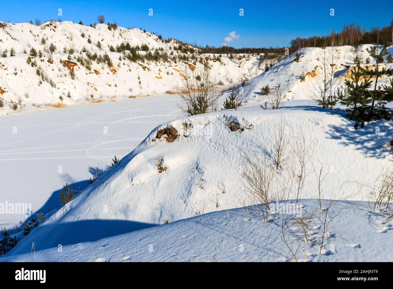 Hills covered with snow in winter with pines, trees and blue sky ...