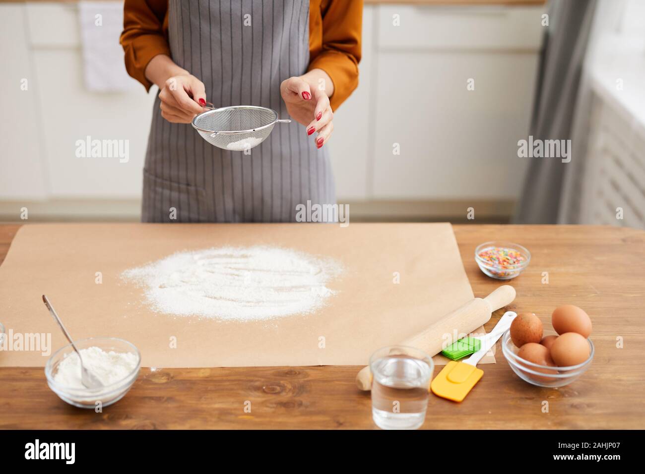 High angle view of unrecognizable woman sifting baking powder while ...