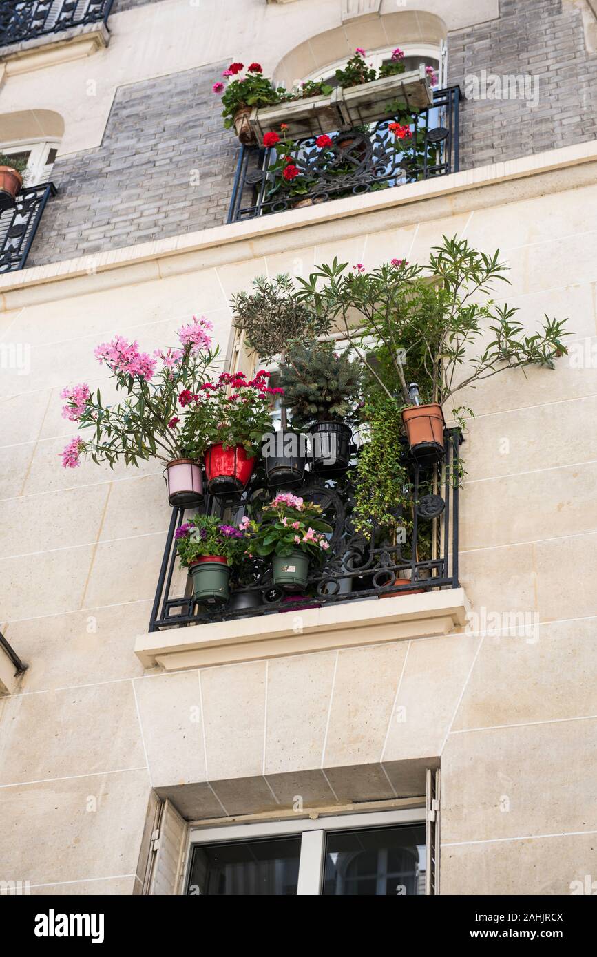 Paris, France - July 03, 2019: Building window covered with potted ...