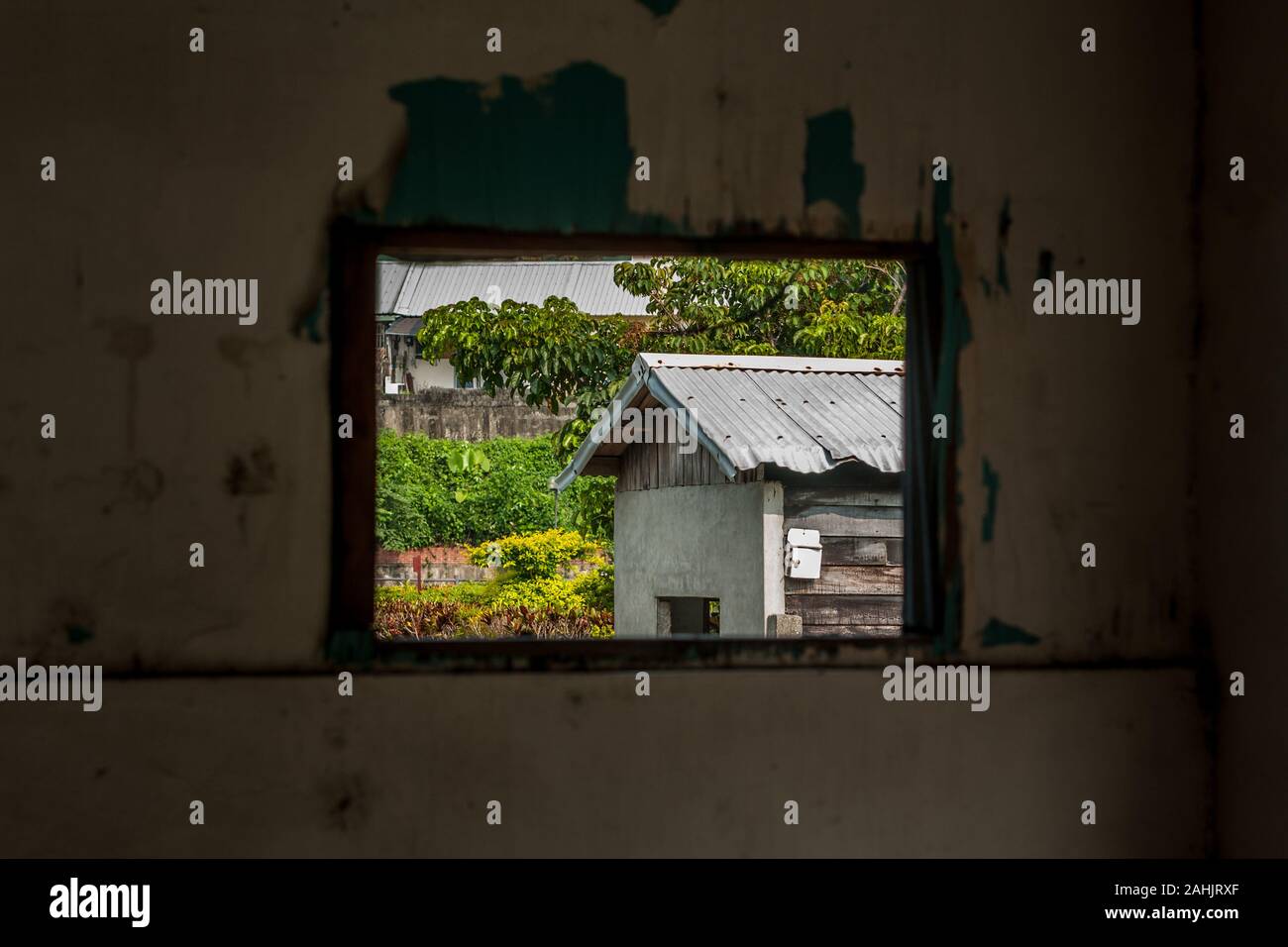 View of the house seen through an old broken window frame inside ...