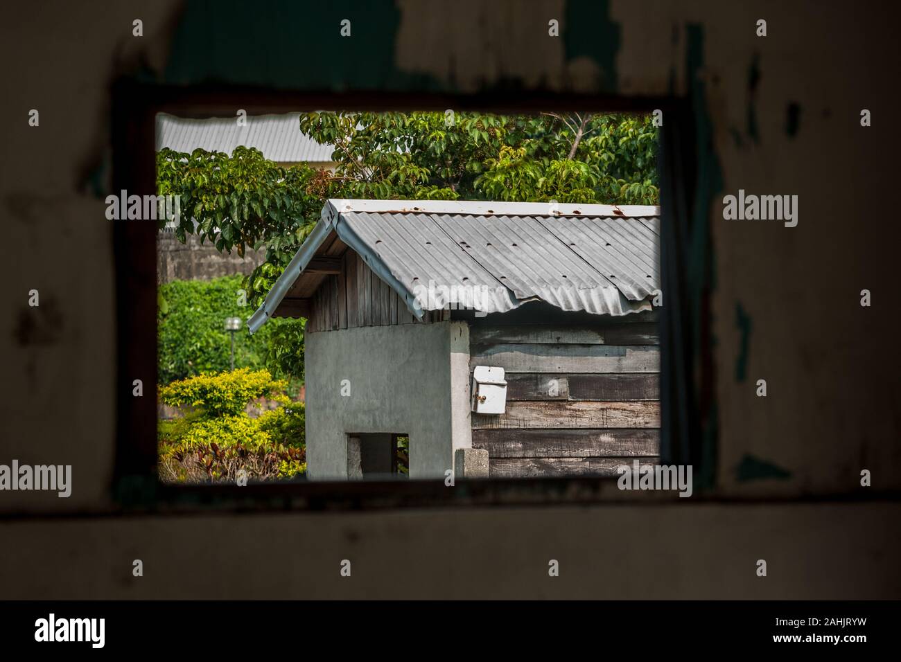 View of the house seen through an old broken window frame inside ...