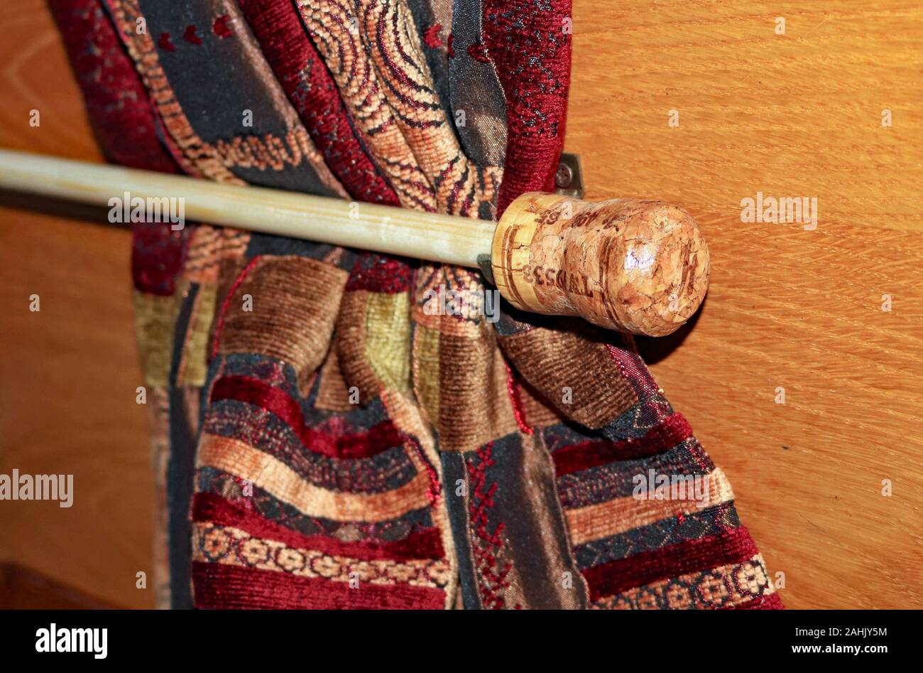 A cork curtain rail end. A fizzy wine bottle cork has been recycled and ...