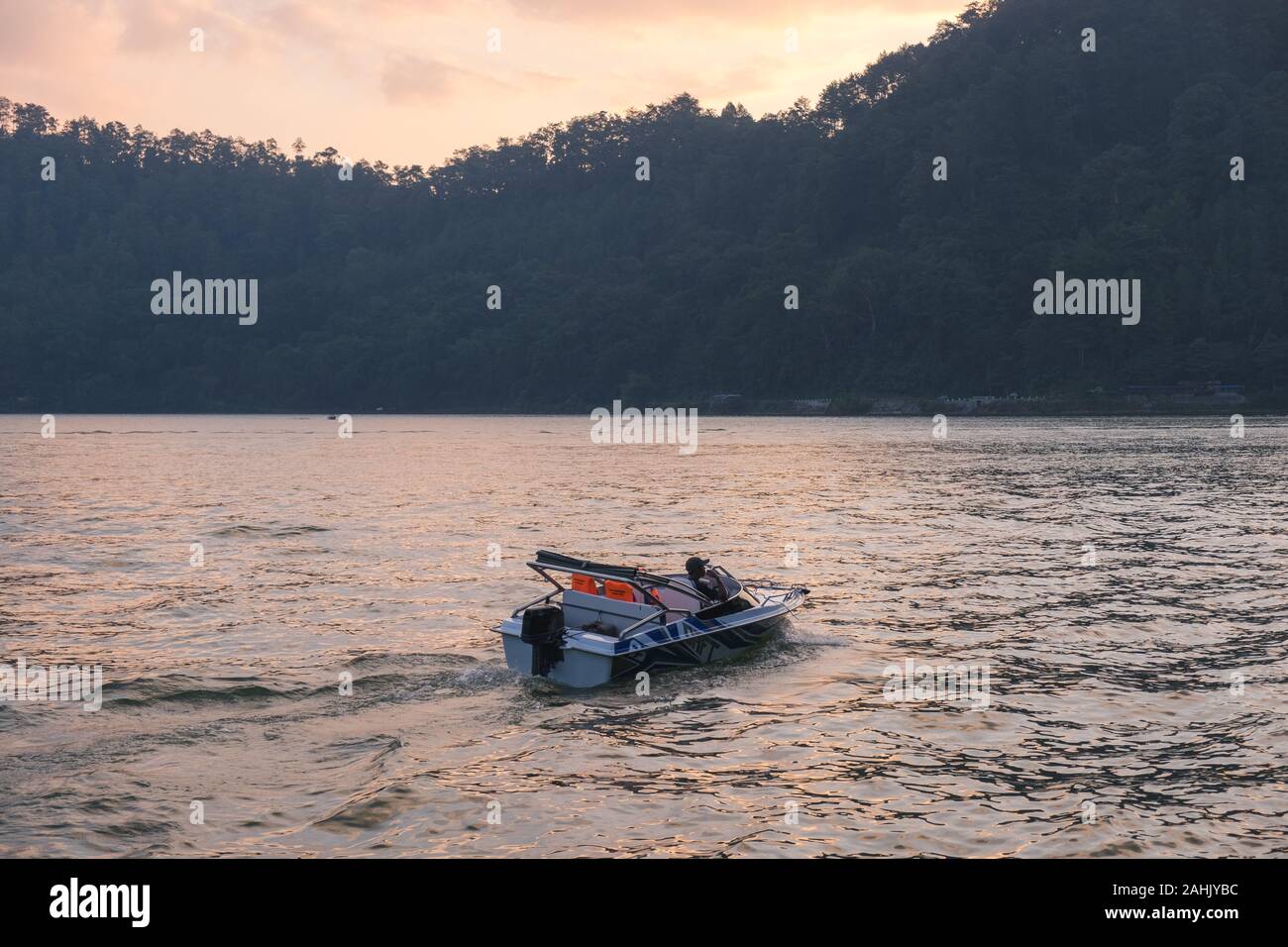 Tourist boat on Ngebel Lake at sunset, Ponorogo, East Java, Indonesia ...
