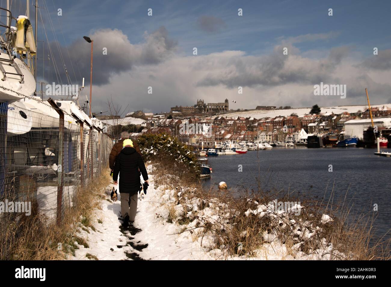 Whitby in winter couple walking Stock Photo - Alamy