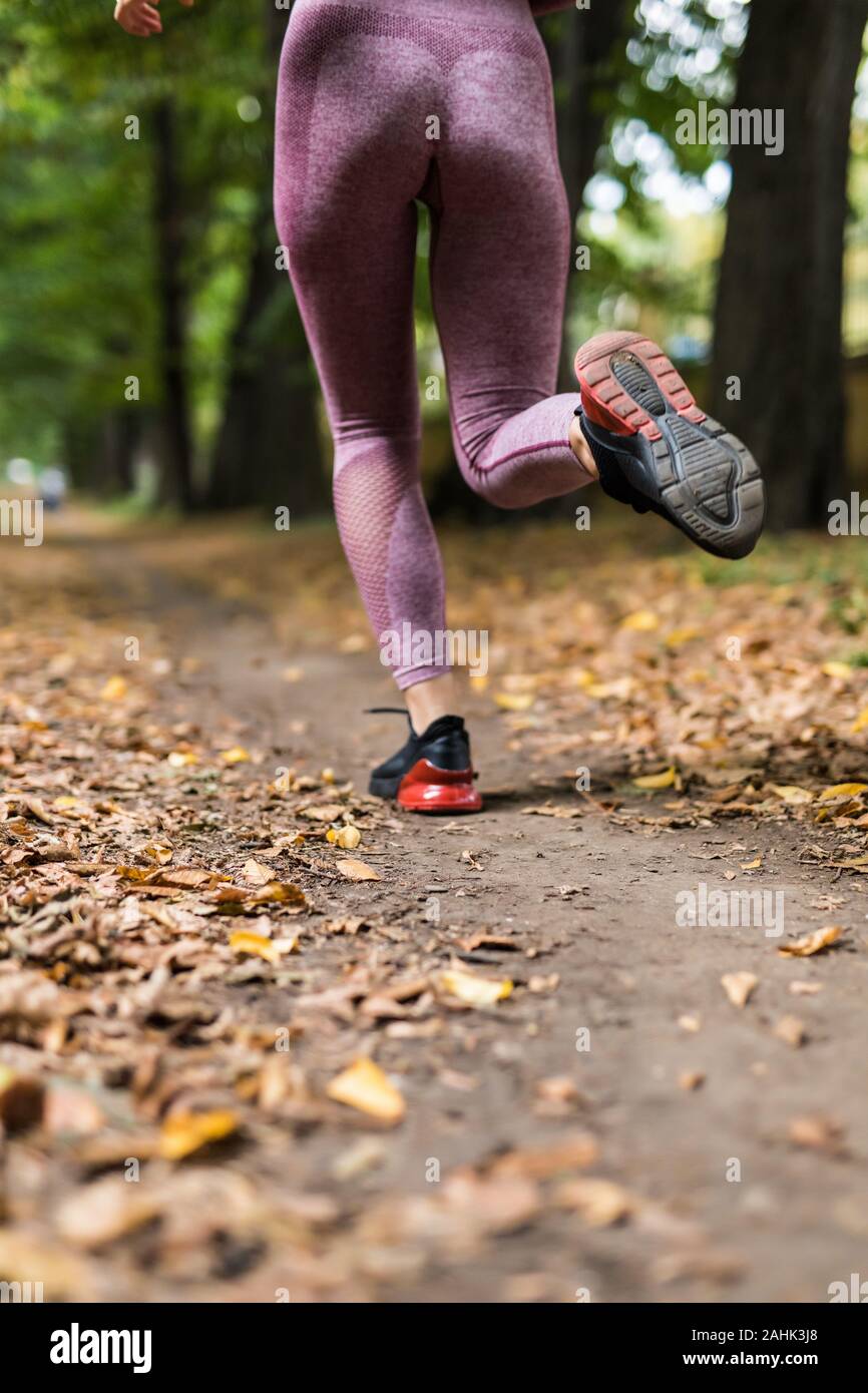 Close up of feet of a runner running in autumn leaves training exercise ...