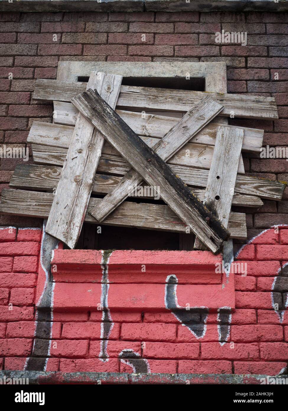 Window closed by wooden planks in an old abandoned brick building Stock ...