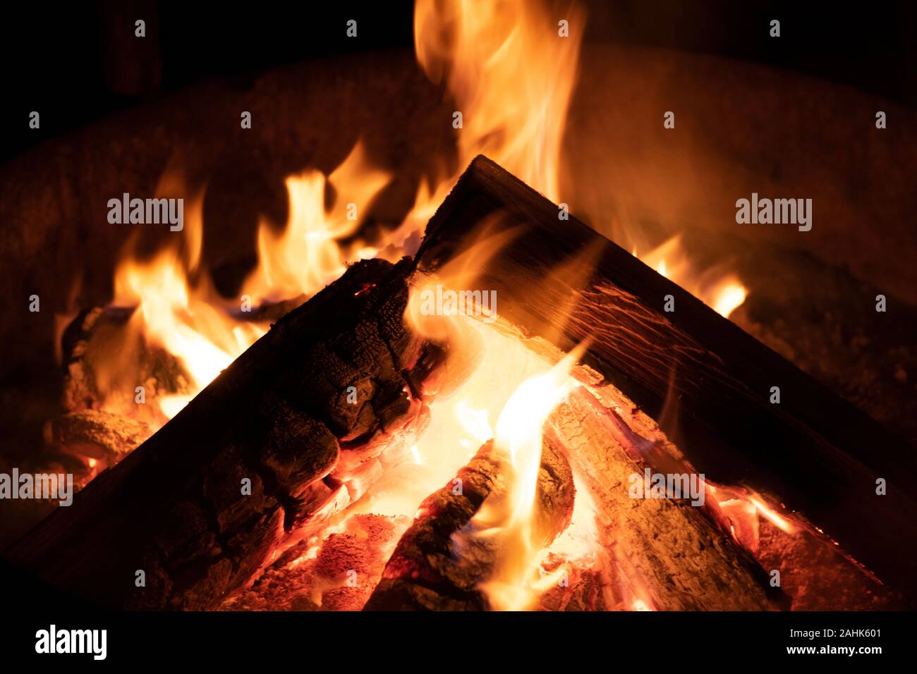 A glowing camp fire providing comfort and light during a cool summer ...