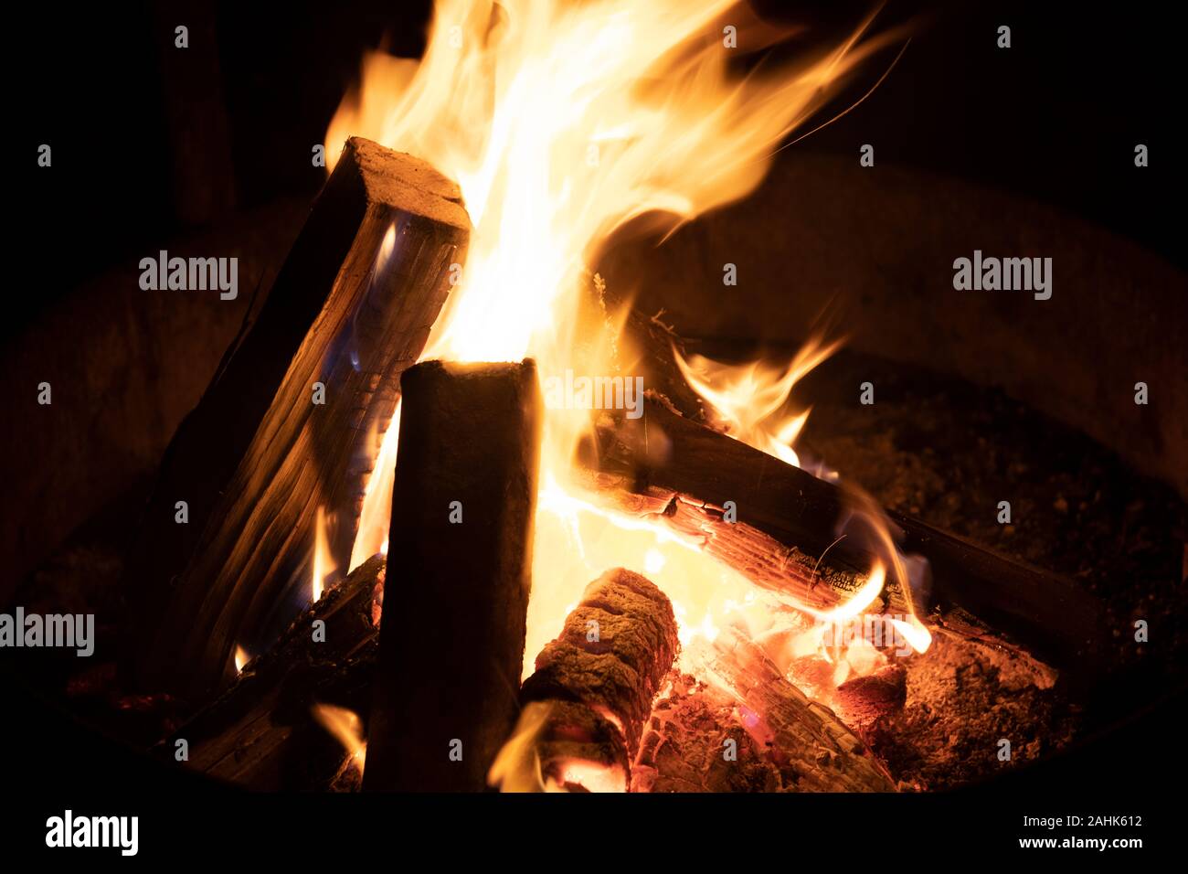 A glowing camp fire providing comfort and light during a cool summer ...
