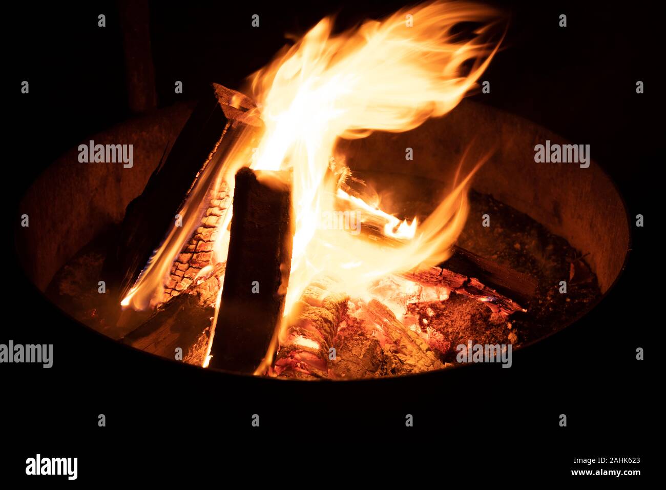 A glowing camp fire providing comfort and light during a cool summer ...