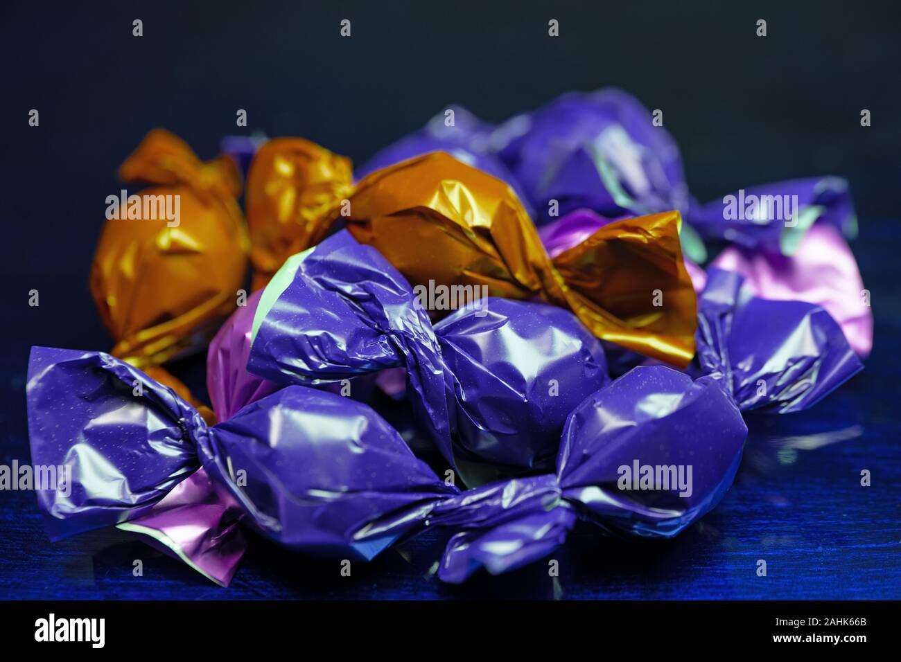 Candy wrapped in colorful foil against a blue background Stock Photo ...
