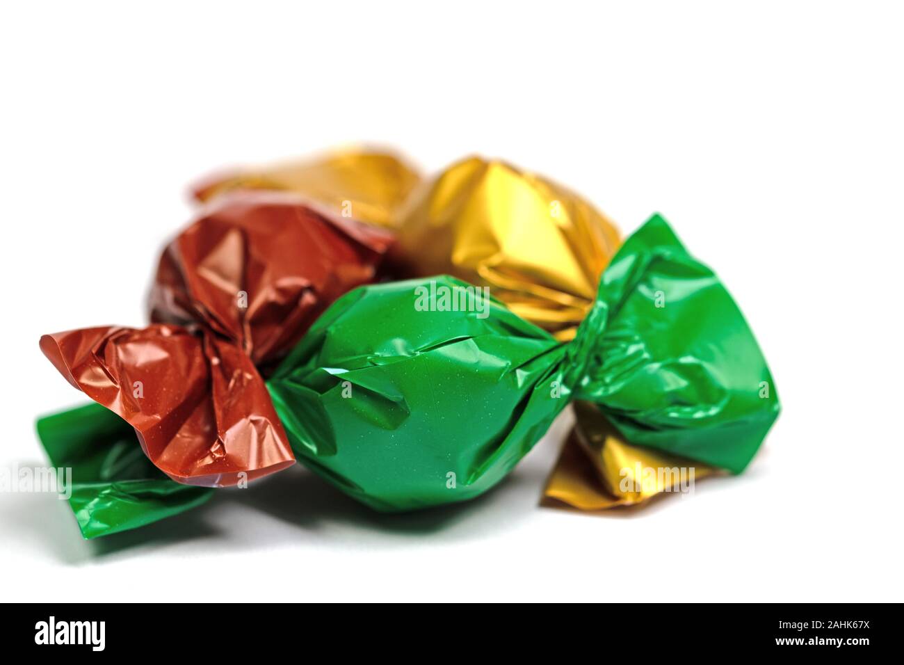 Candy wrapped in colorful foil against white background Stock Photo - Alamy
