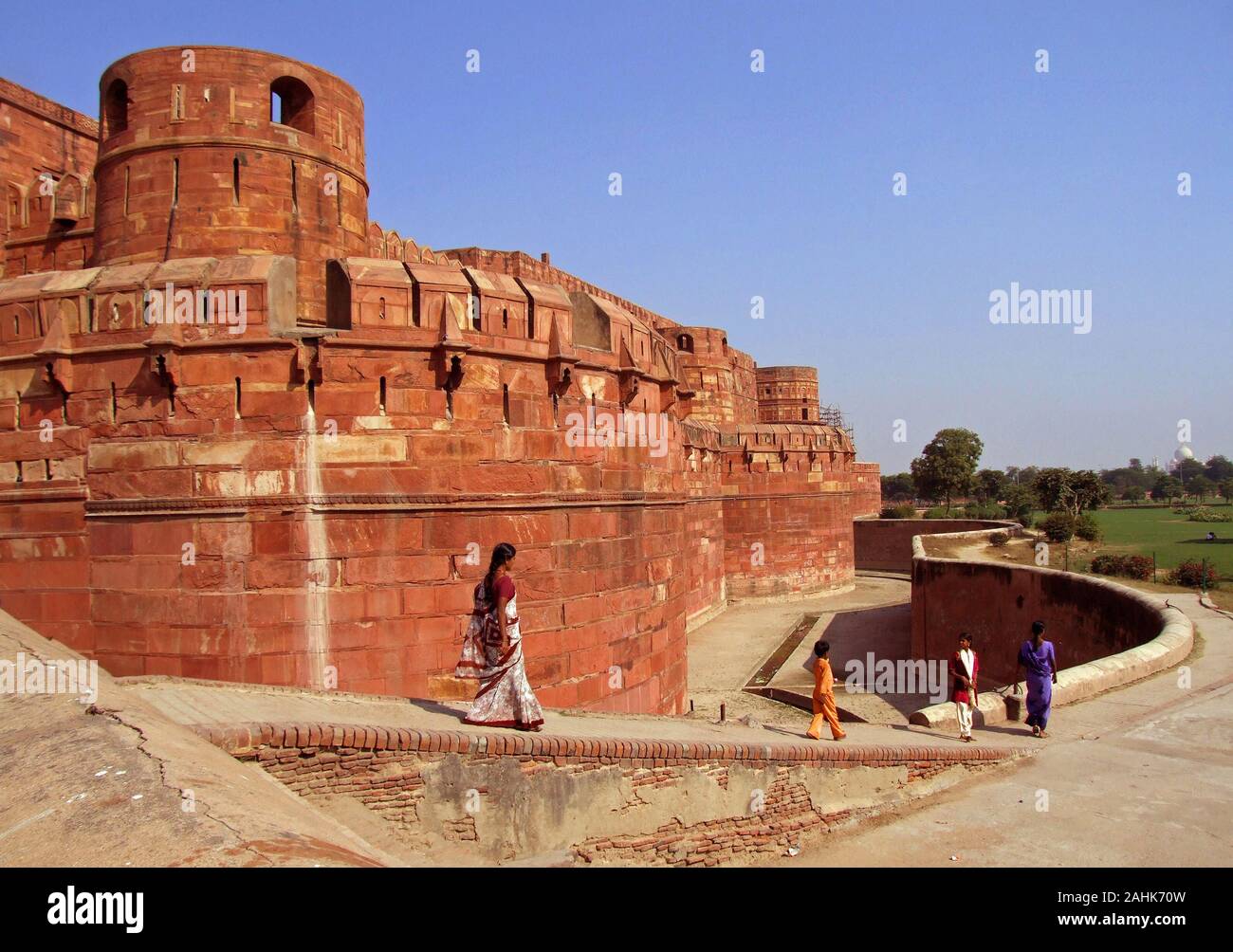 Indian women in saris walking in front of The Red Fort at Agra with the ...