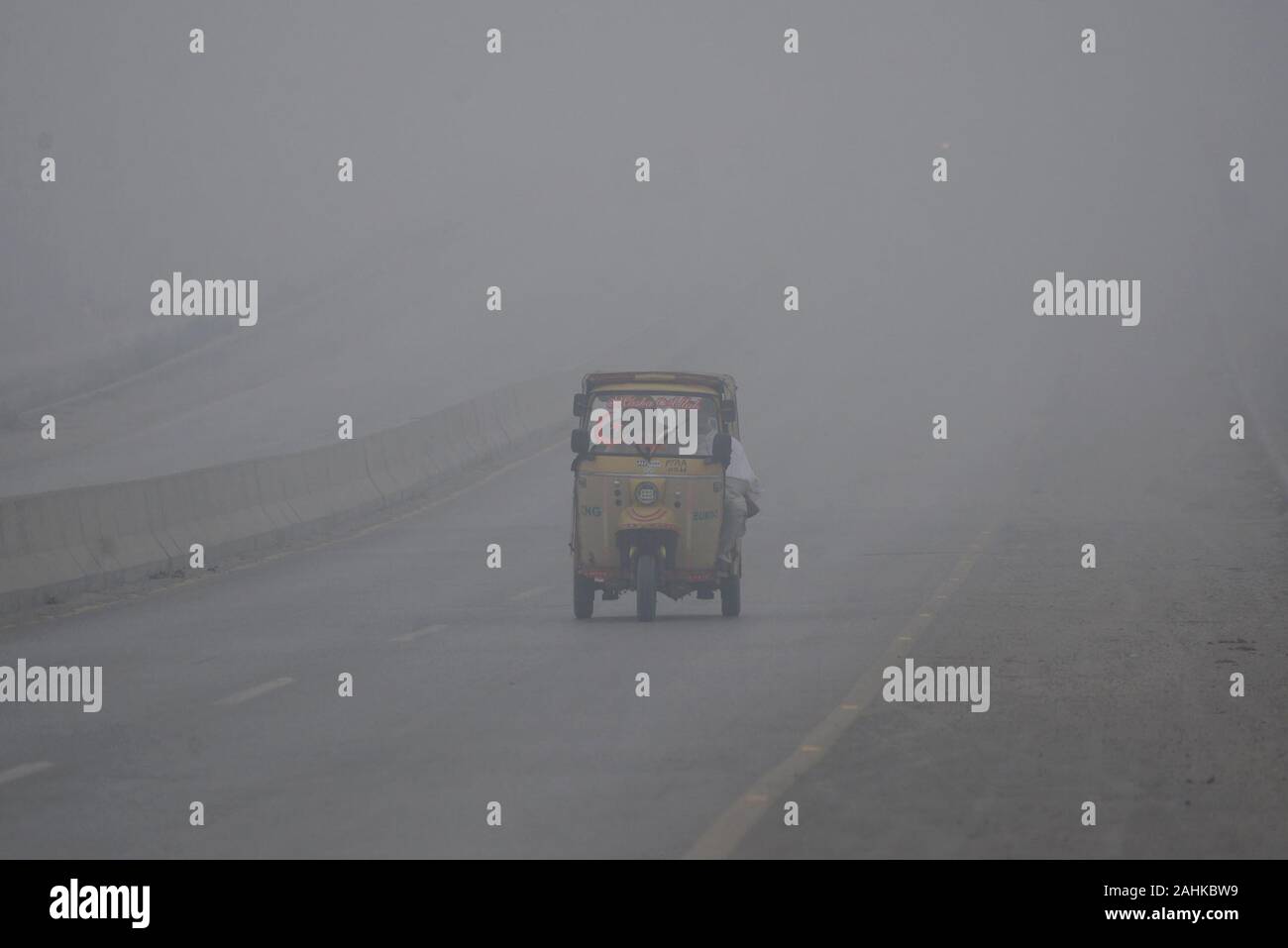 Peshawar. 30th Dec, 2019. A vehicle moves on a road in dense fog in ...