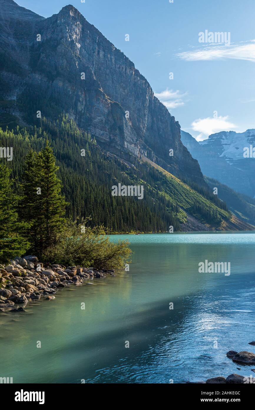 Majestic turquoise colored Lake Louise surrounded by towering mountains ...