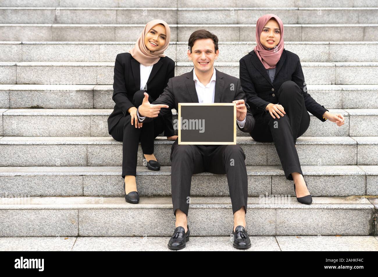 Group of business staff sit at staircase Stock Photo - Alamy