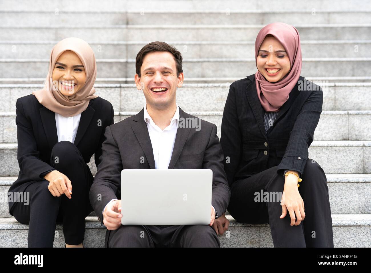 Group of business staff sit at staircase Stock Photo - Alamy