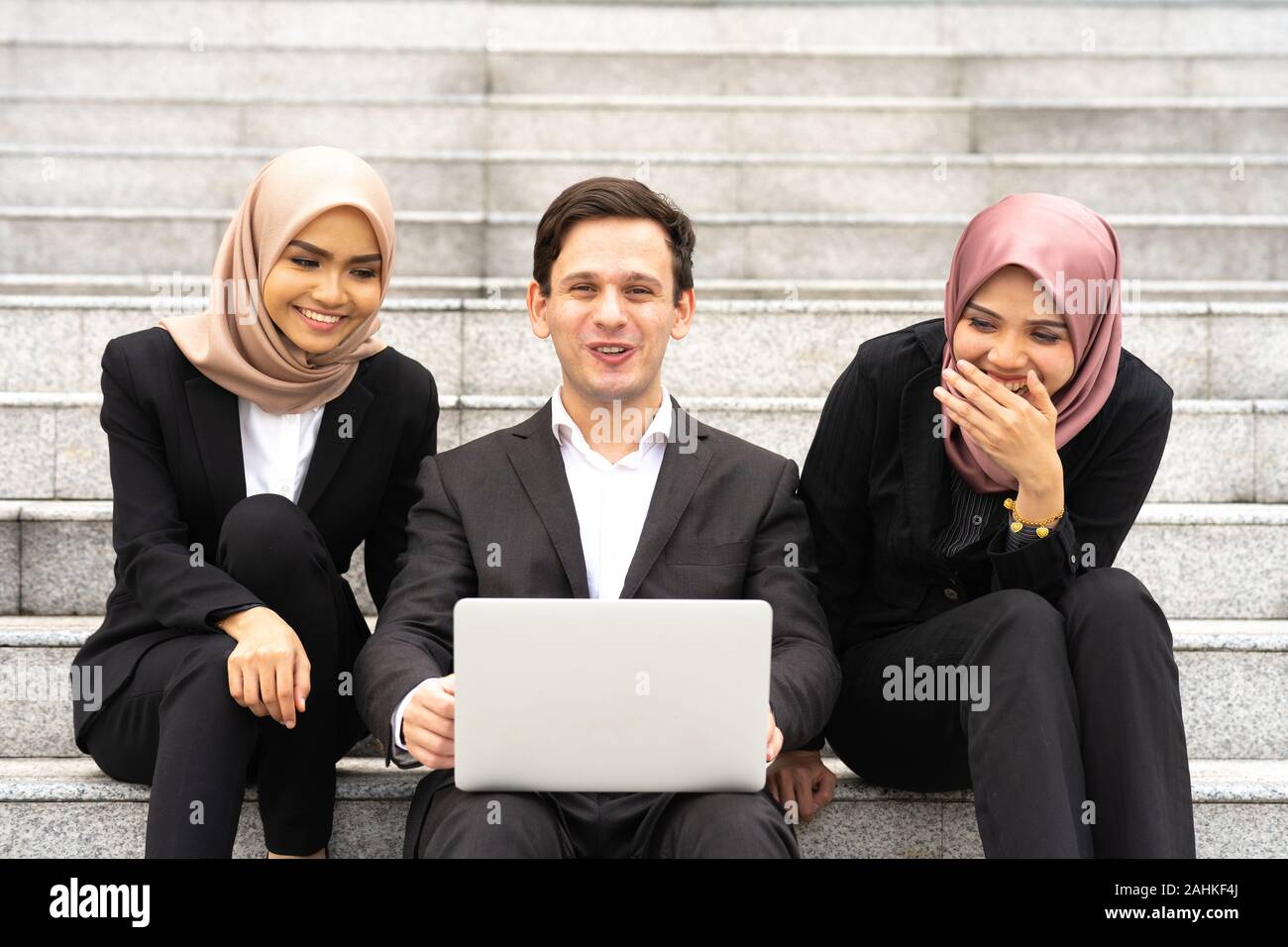 Group of business staff sit at staircase Stock Photo - Alamy