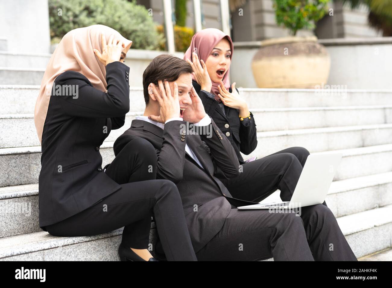 Group of business staff sit at staircase Stock Photo - Alamy